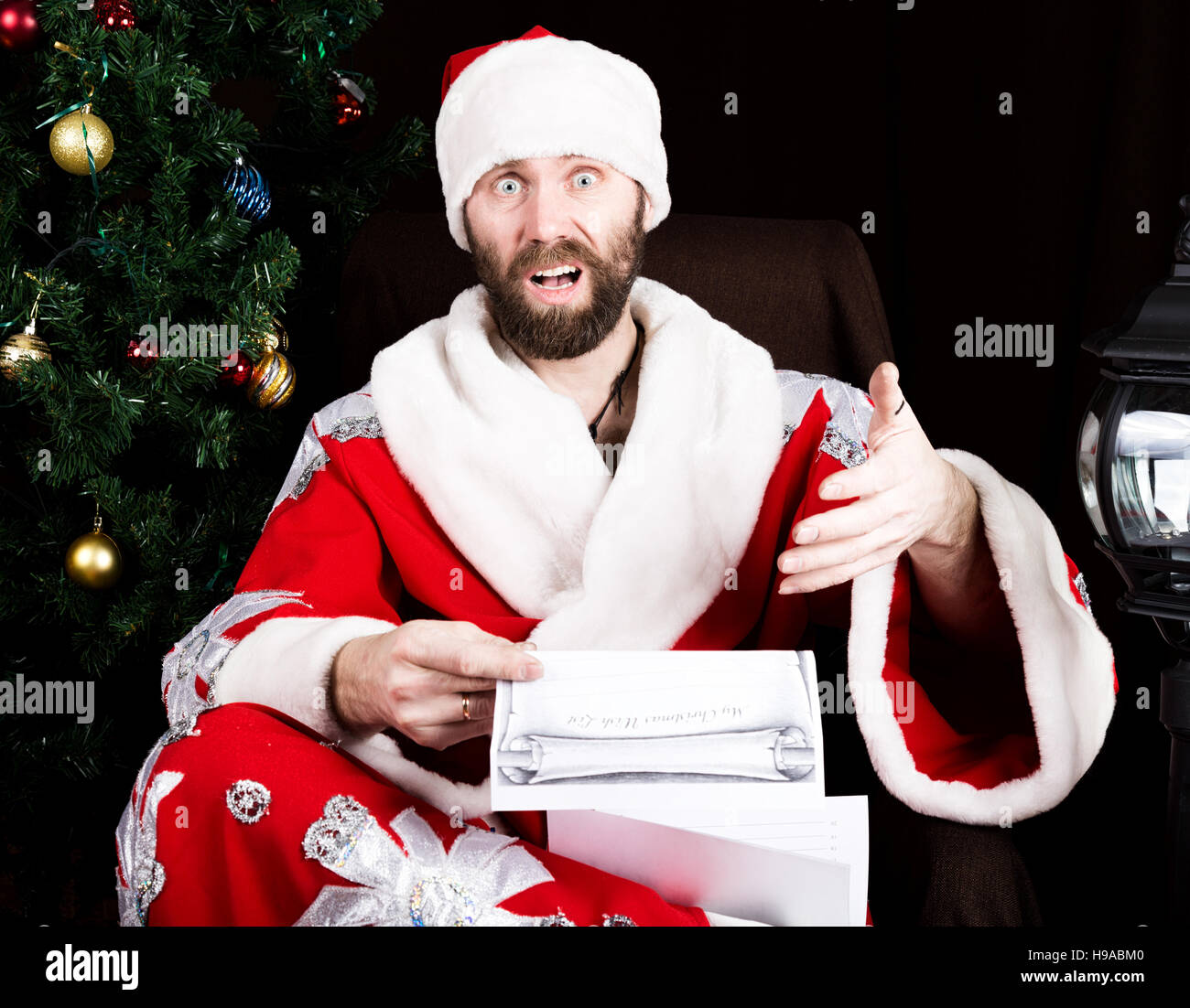 bad brutal Santa Claus discontentedly reads letter with the wishes, on ...