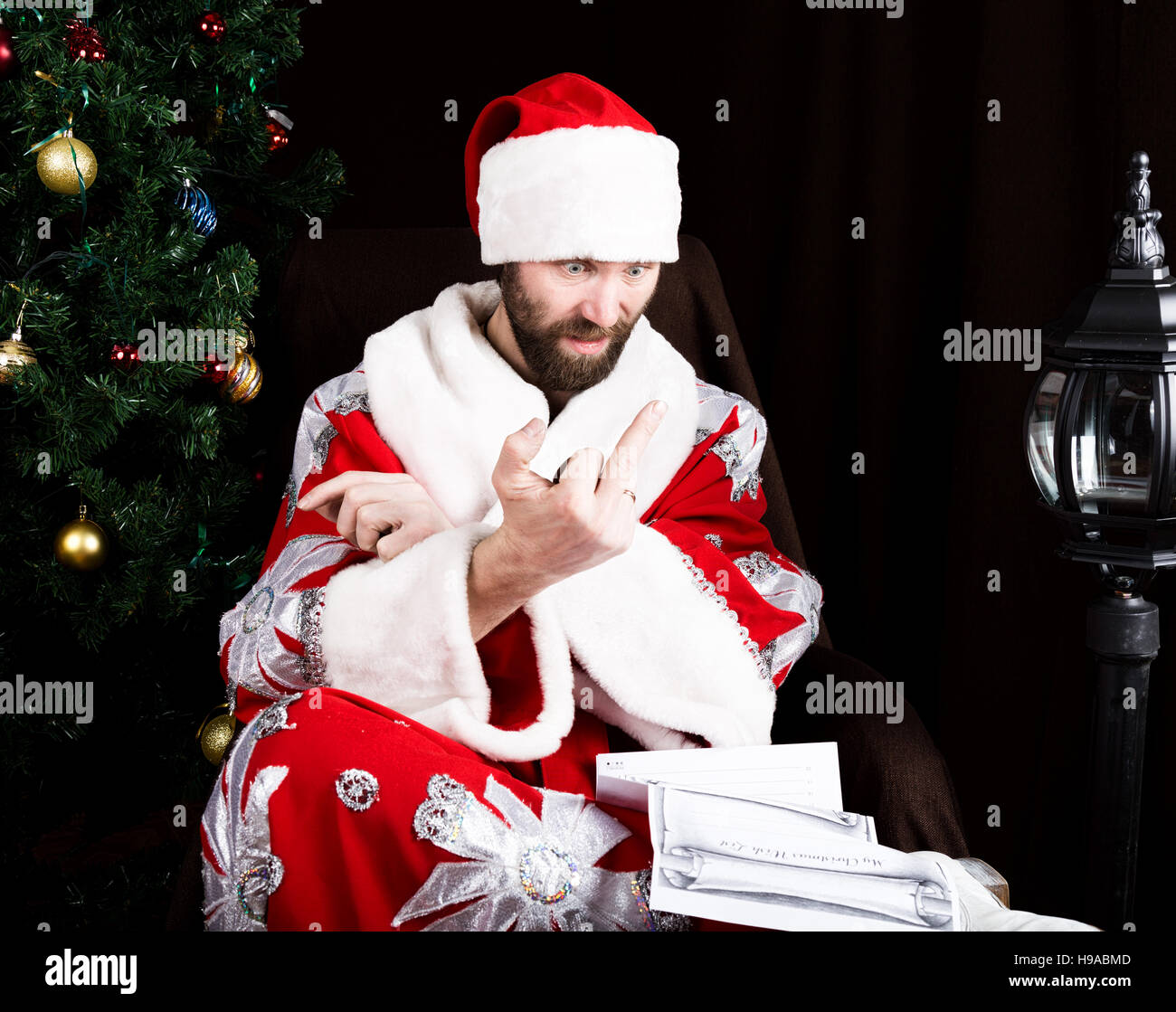 bad brutal Santa Claus discontentedly reads letter with the wishes and ...