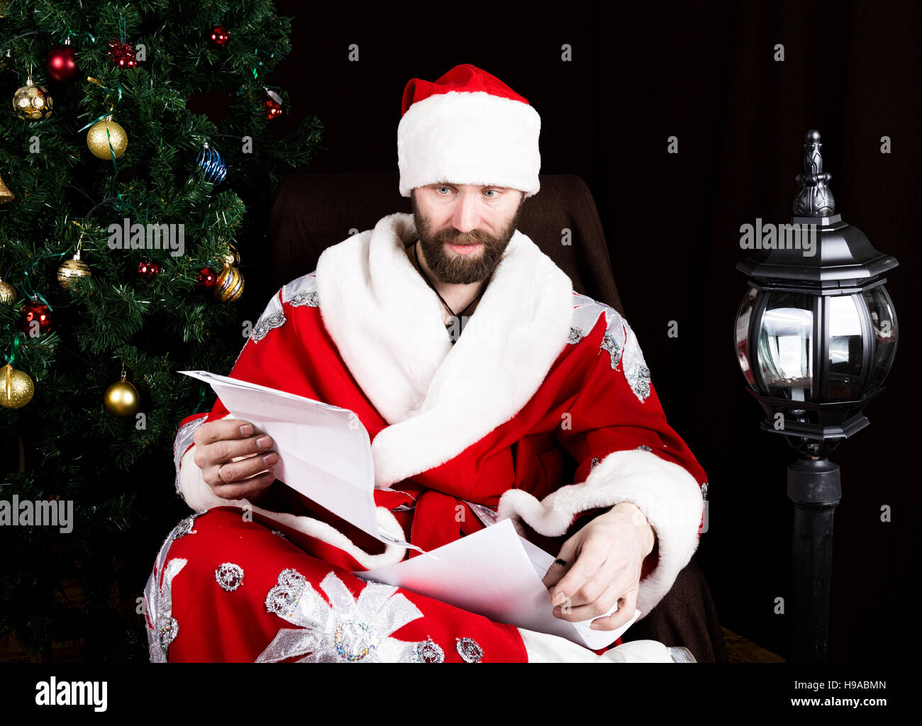 bad brutal Santa Claus discontentedly reads letter with the wishes, on ...