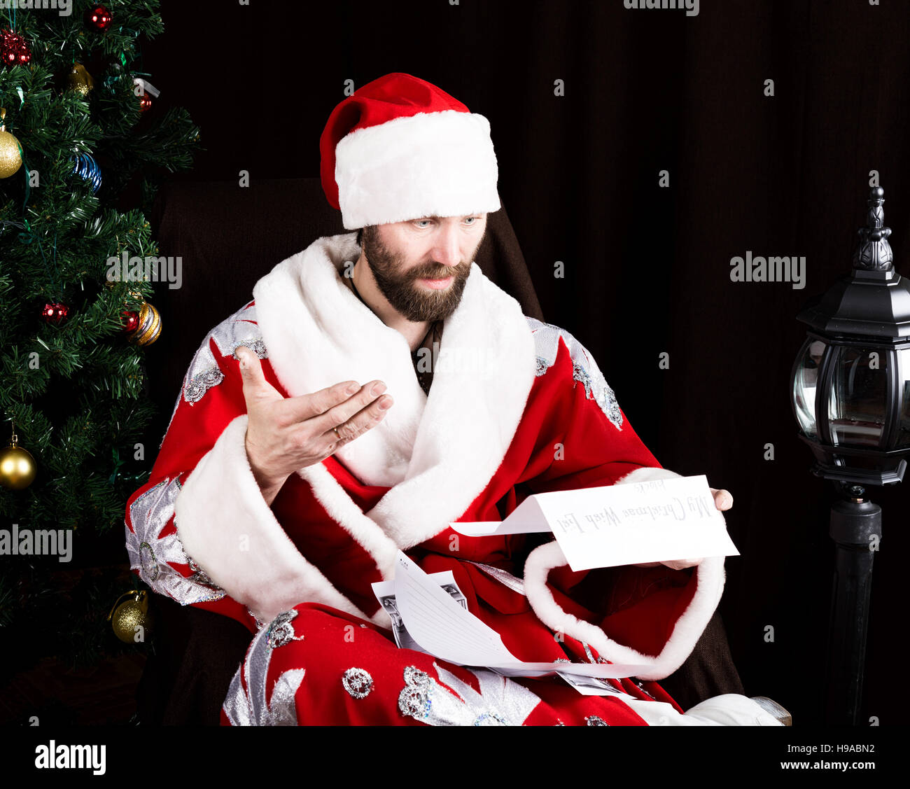 bad brutal Santa Claus discontentedly reads letter with the wishes, on ...