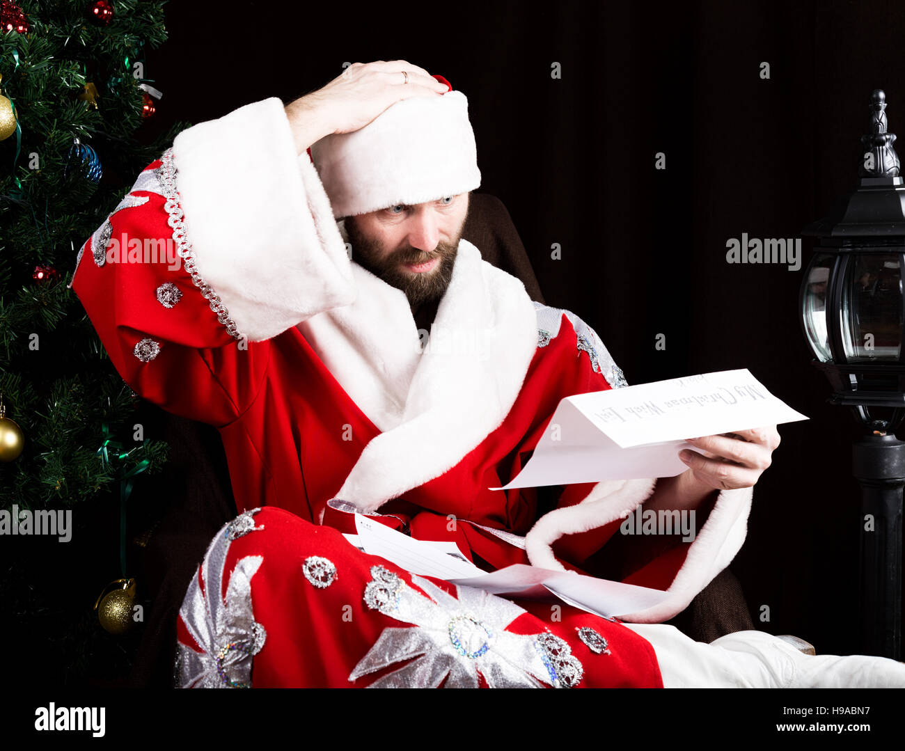 bad brutal Santa Claus discontentedly reads letter with the wishes, on ...
