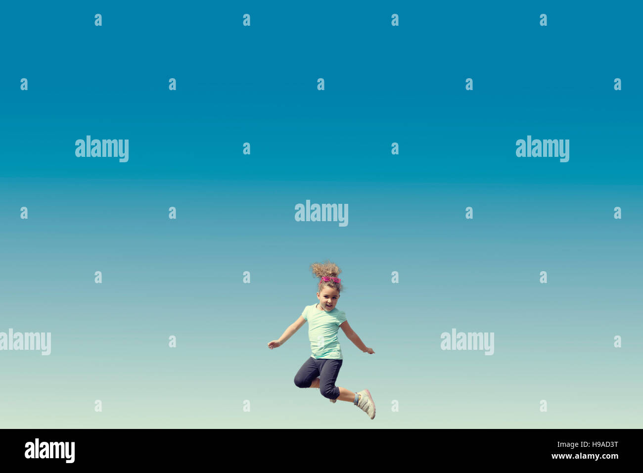 A little kid jumps into the sky. Horizontal outdoors shot Stock Photo ...