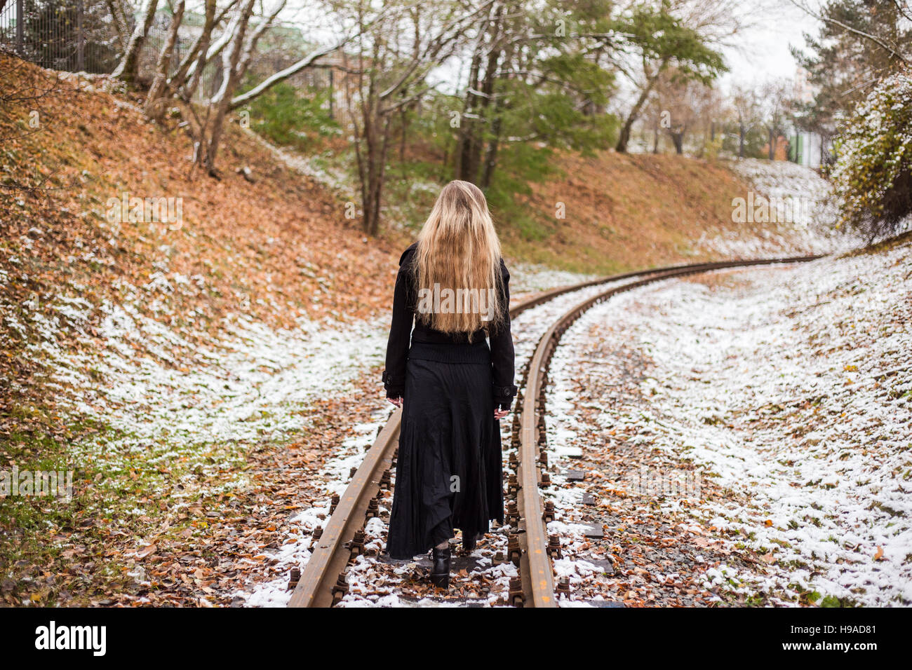 Woman walking on railway tracks Stock Photo - Alamy