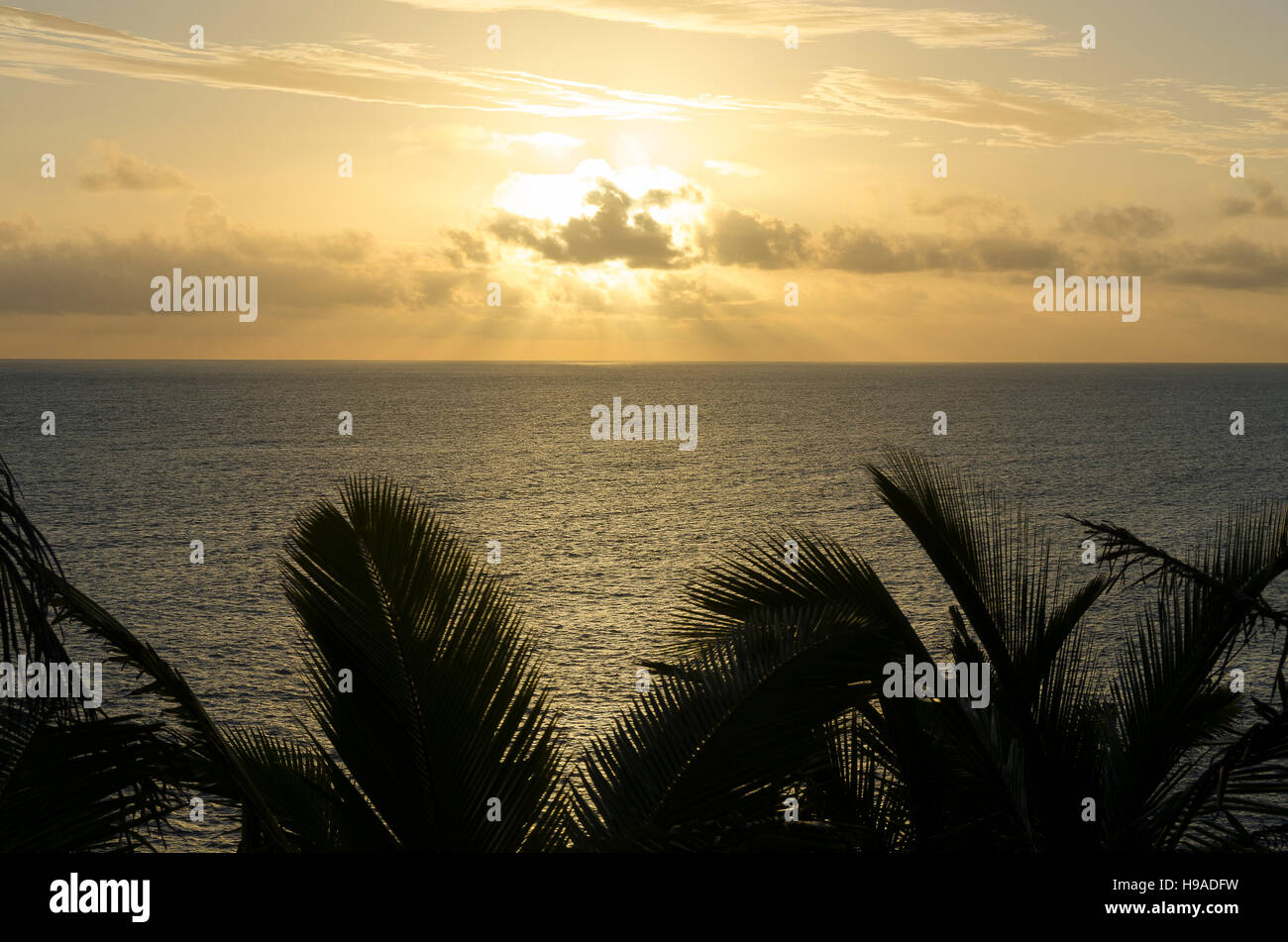 Late afternoon sun shining through clouds, Makefu, Niue, South Pacific ...