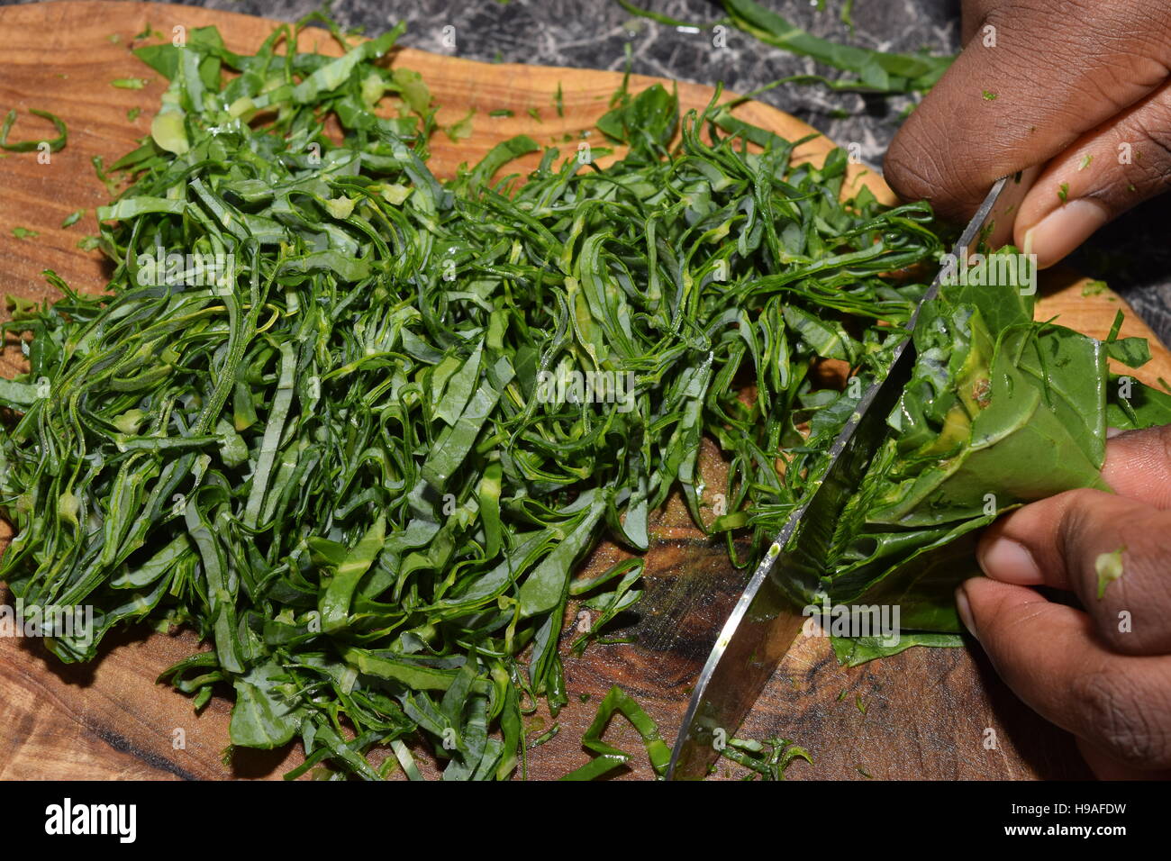 African female hands cutting spinach on a wooden board Stock Photo - Alamy