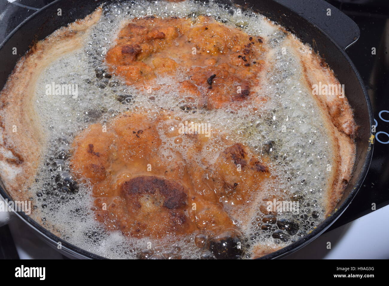 Close-up of wiener schnitzel frying Stock Photo - Alamy