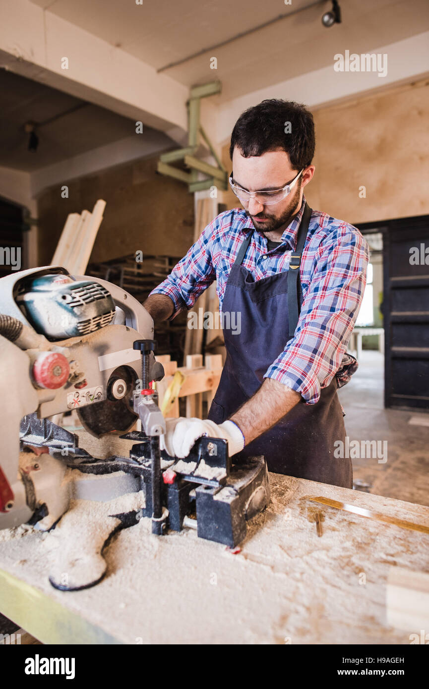 Young craftsman in uniform working at carpentry Stock Photo - Alamy