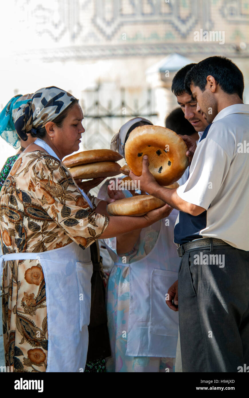 Men and women haggling over bread at a market in Samarkand, Uzbekistan ...
