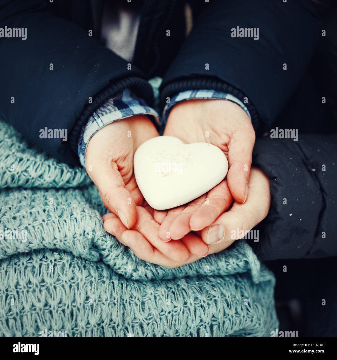 Man and woman hands holding gingerbread heart in white icing, close-up ...