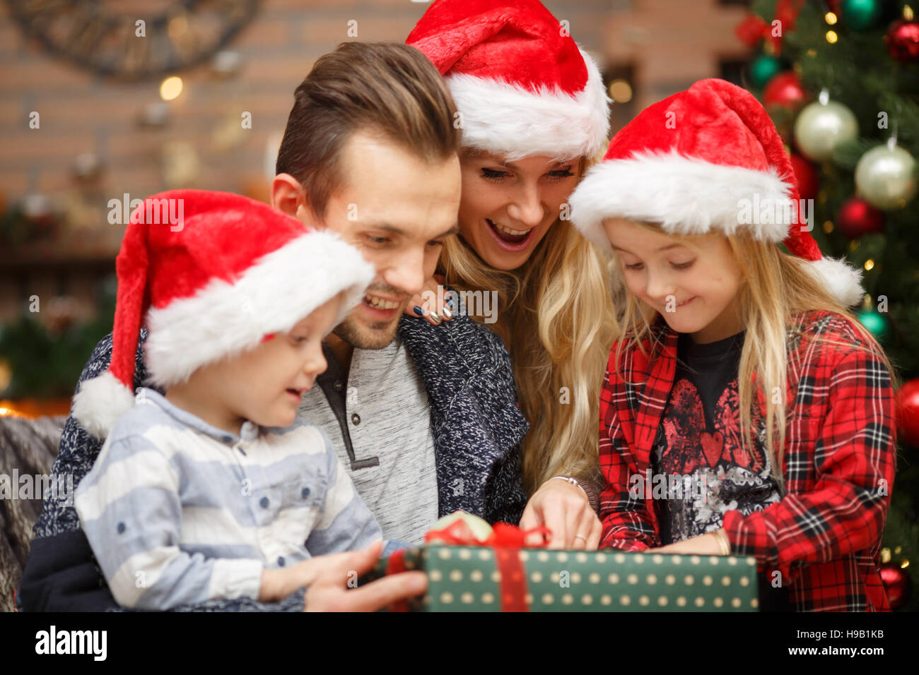 Parents with kids open gifts Stock Photo - Alamy