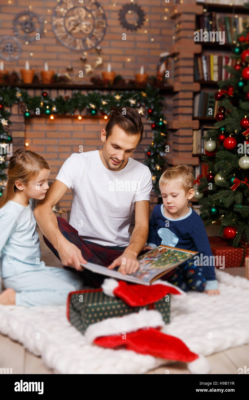 Dad reads book to children Stock Photo - Alamy