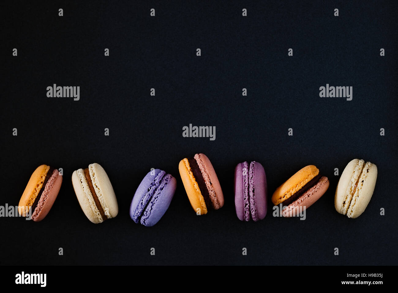 Colorful French Macaroons on a dark background. Copy space. Horizontal ...