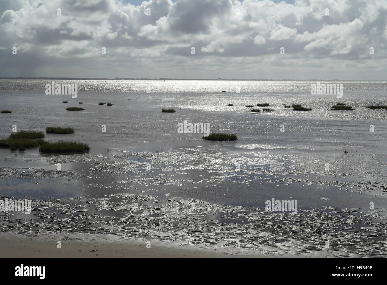 Grey clouds sun view Fairhaven Outer Promenade over wet beach sand with ...