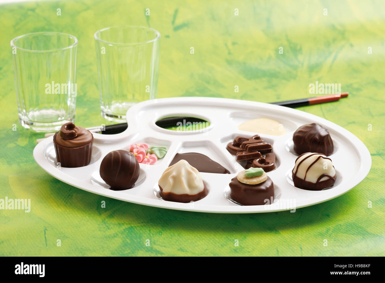Filled chocolates on a colour palette Stock Photo - Alamy