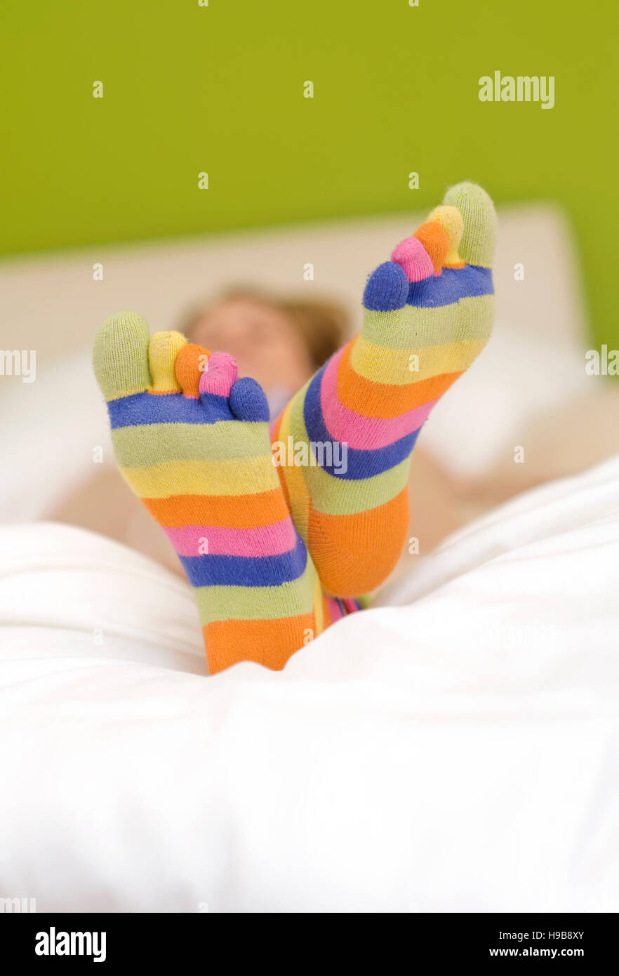 Feet with colourful toe socks in bed Stock Photo - Alamy