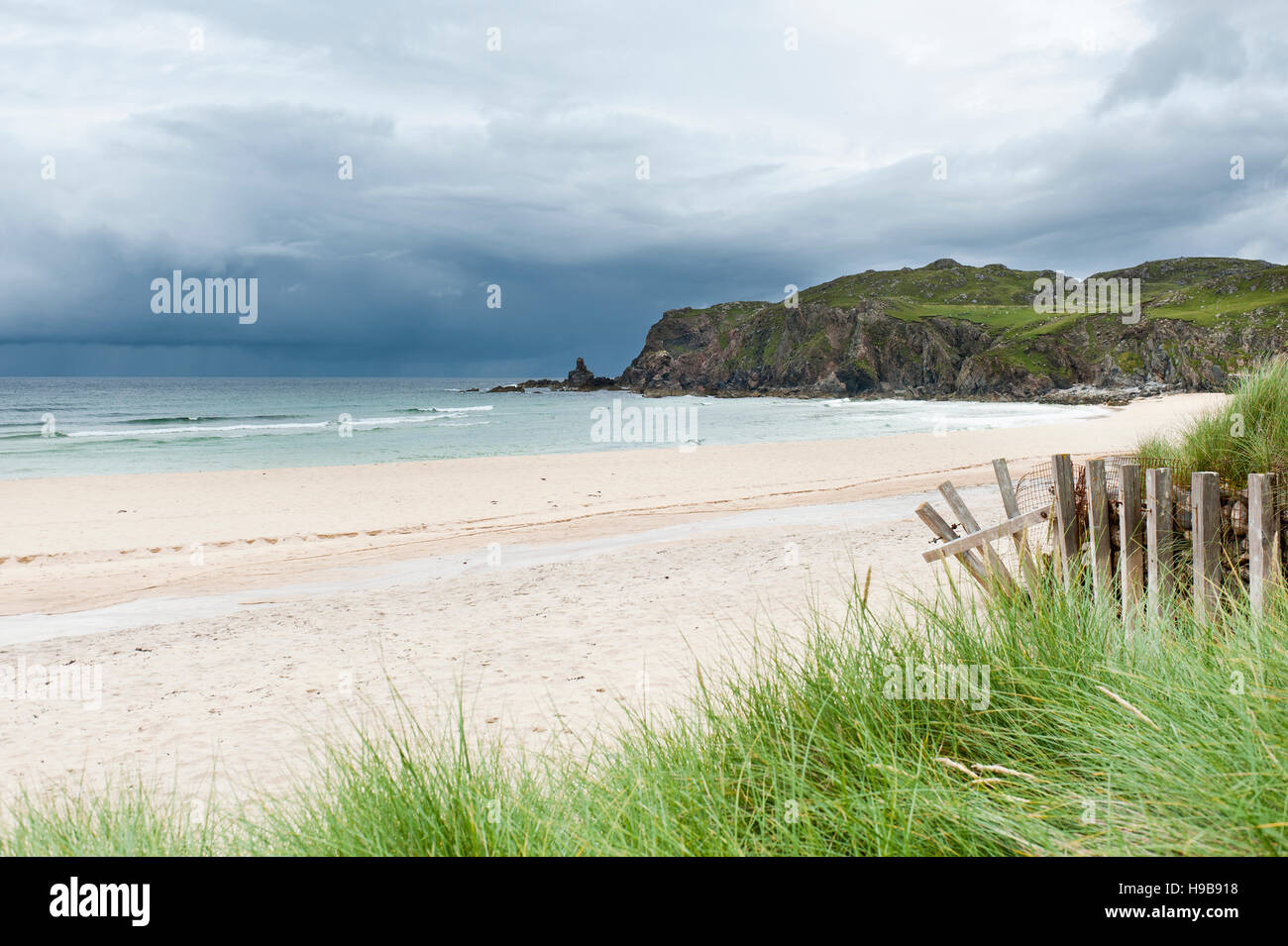 Sandy beach with dark clouds over the coast, Dail Mòr Beach, Dalmore ...