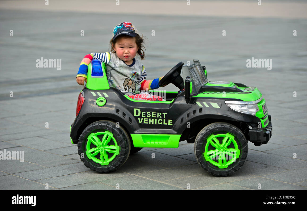 Little girl rides in electric toy car, Genghis Khan Square, Ulaanbaatar ...