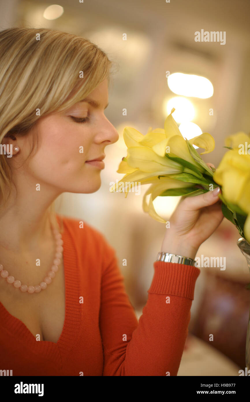 Young woman smelling a flower Stock Photo - Alamy