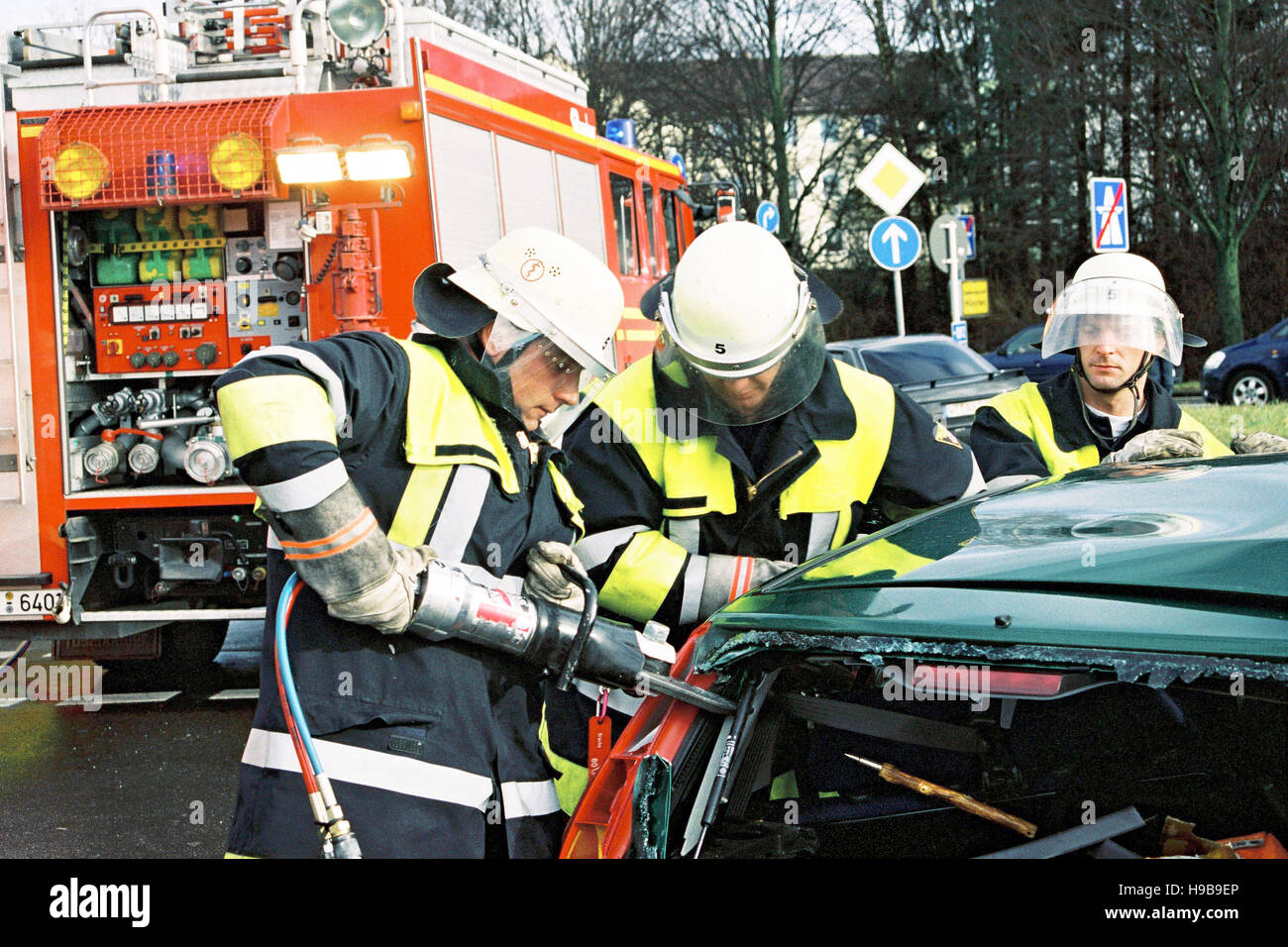 Firemen at traffic accident using Jaws of Life to rescue trapped car ...