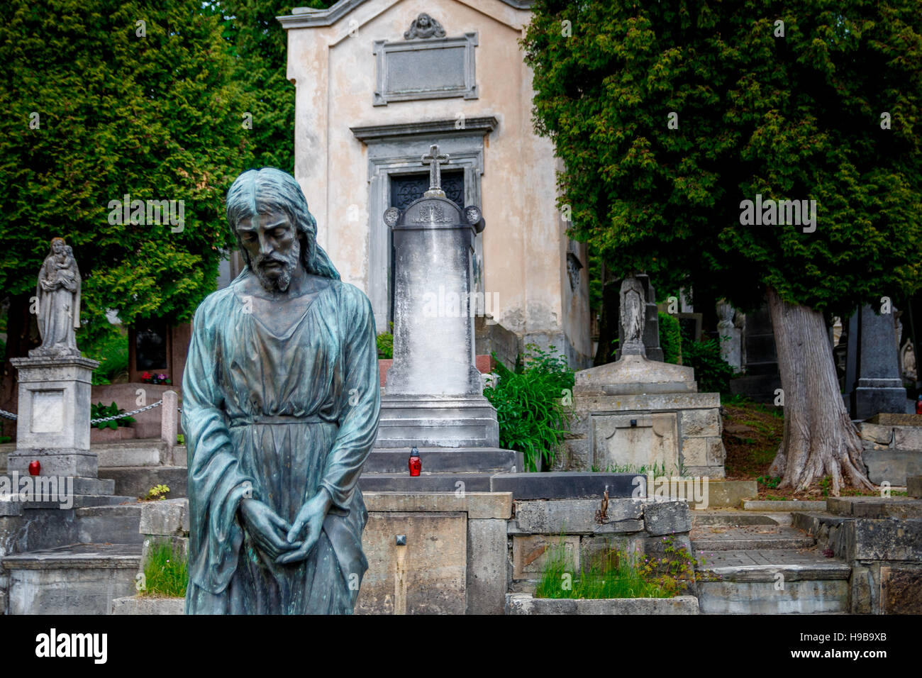 Cemetery with a sad man statue on the foreground. religion Stock Photo ...