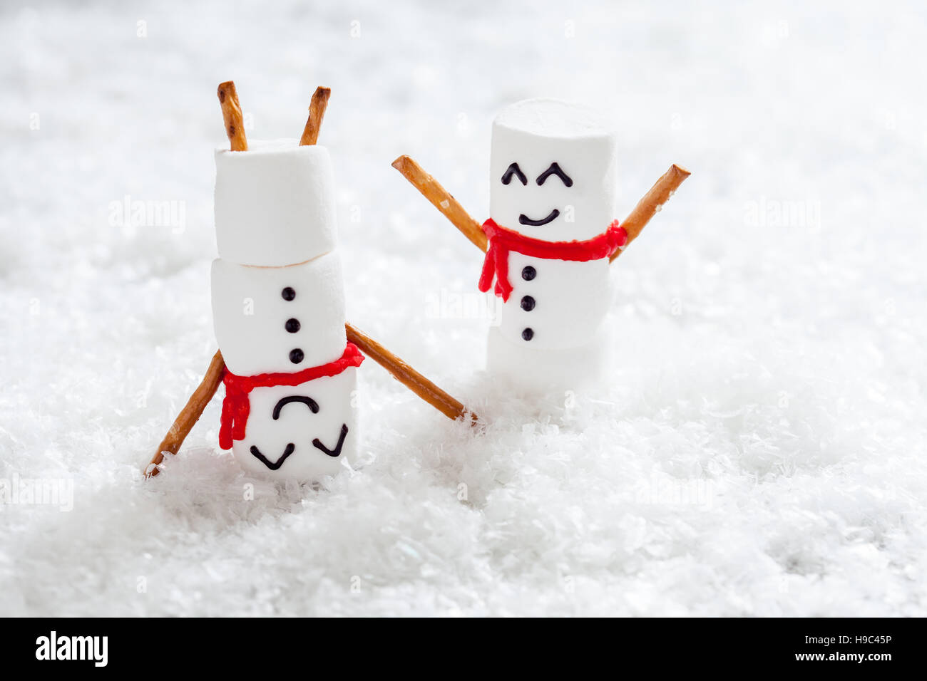 Happy funny marshmallow snowmans on snow Stock Photo - Alamy