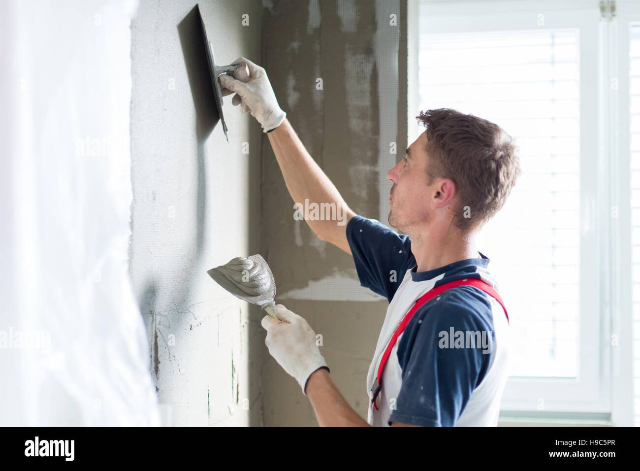 Plasterer renovating indoor walls and ceilings Stock Photo - Alamy