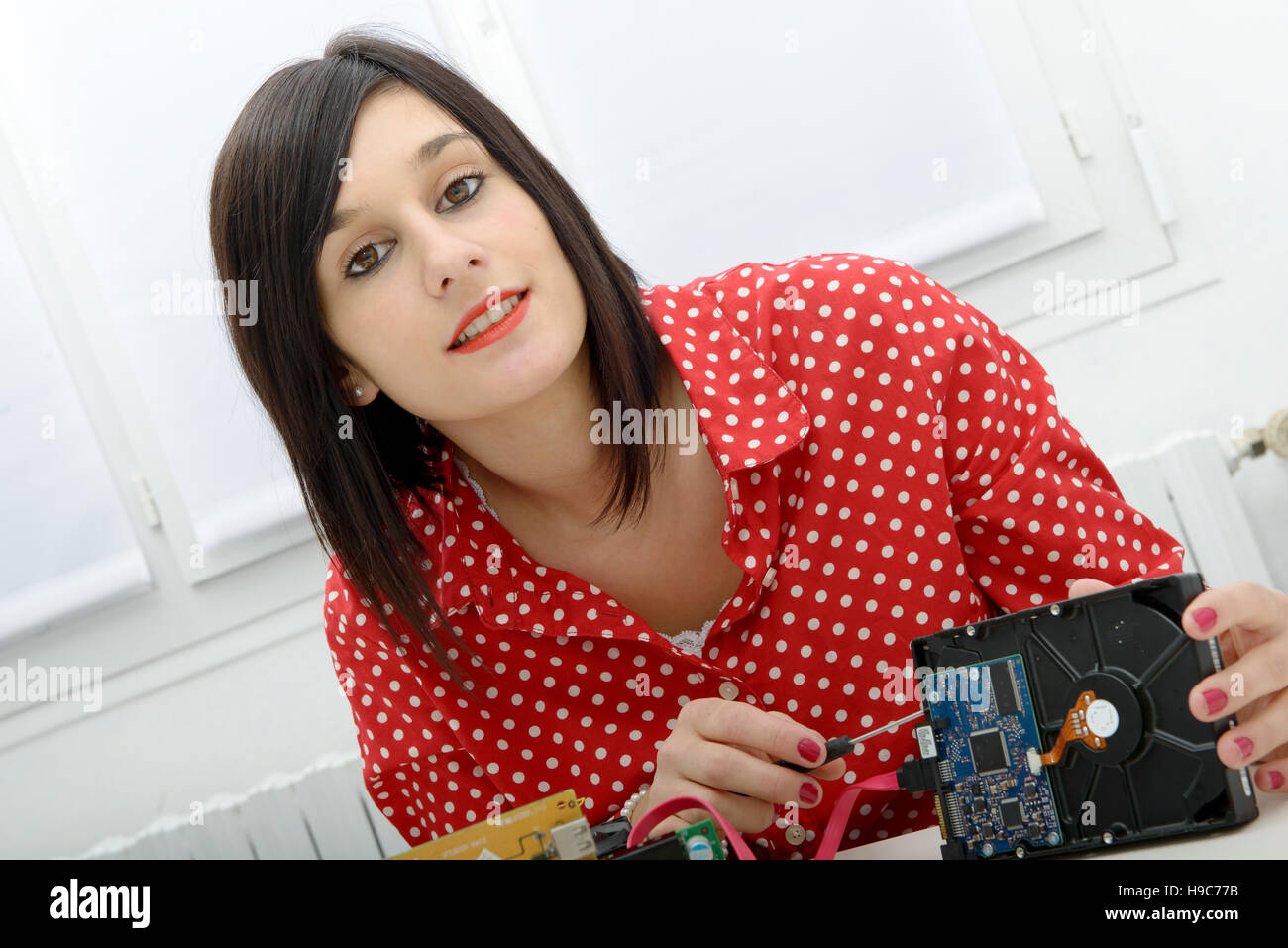 Young smiling brunette woman technician repairs a computer Stock Photo ...