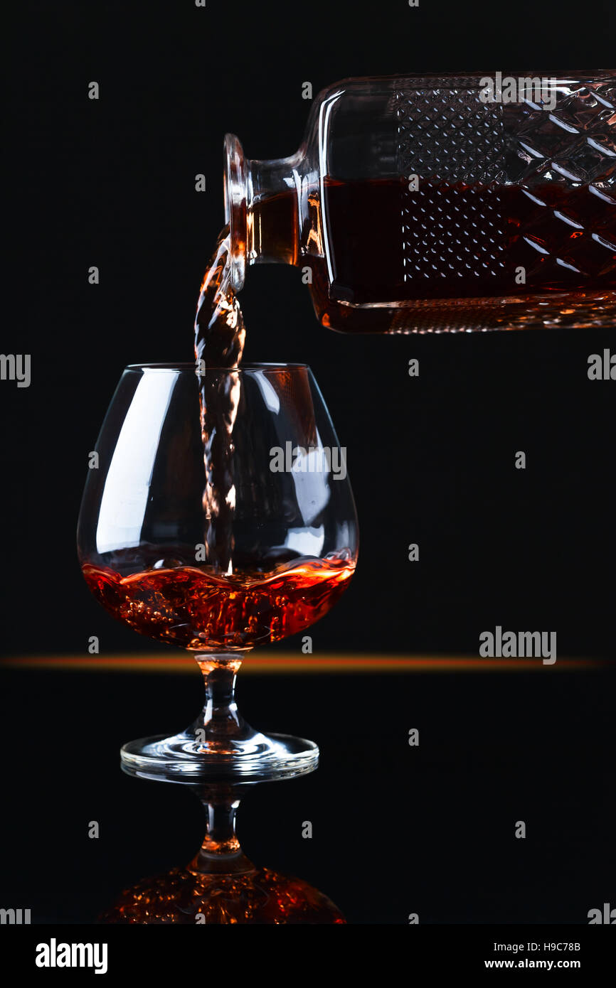 Snifter with brandy on a black background Stock Photo - Alamy
