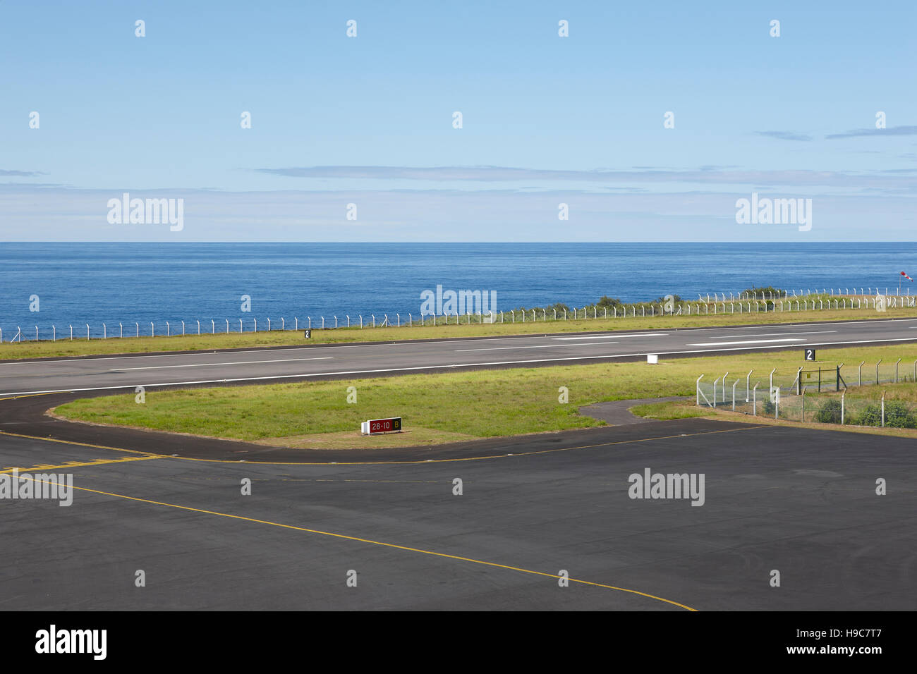 Airport runway close to the ocean with lines and fence. Horizontal ...