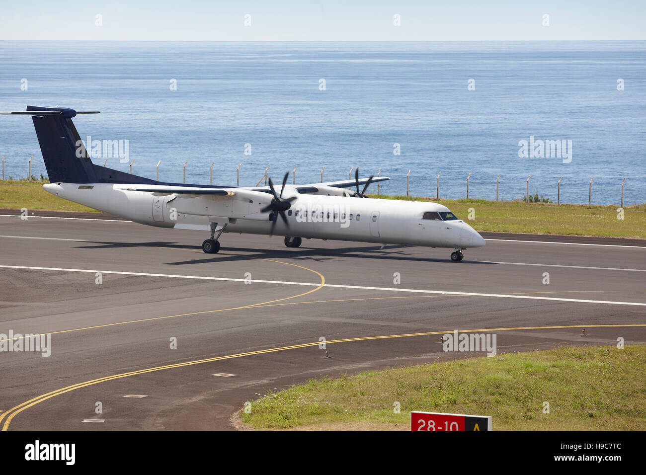 Airplane on the airport runaway near the ocean just arrived. Horizontal ...