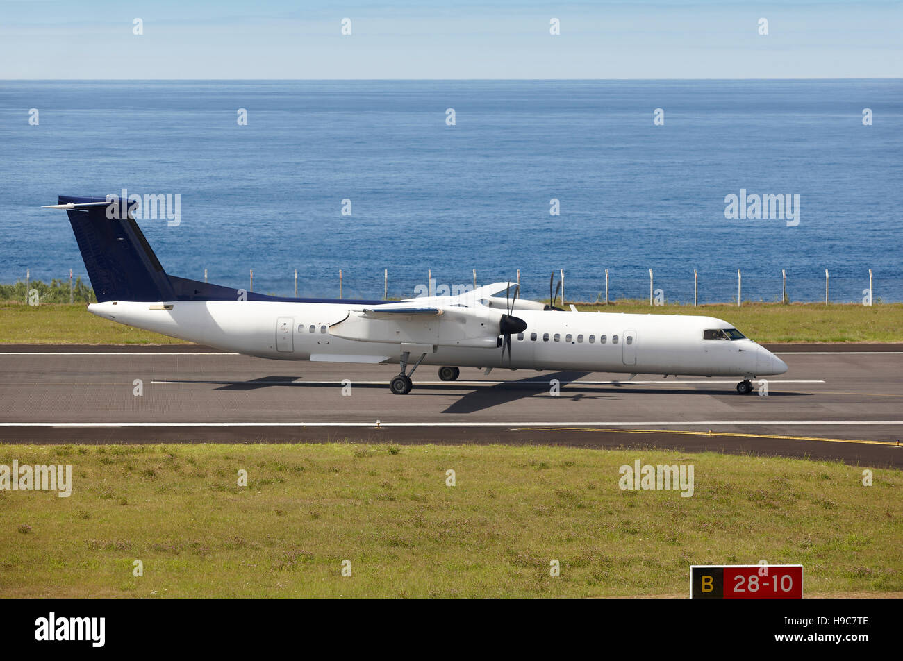 Airplane on the airport runaway near the ocean just arrived. Horizontal ...