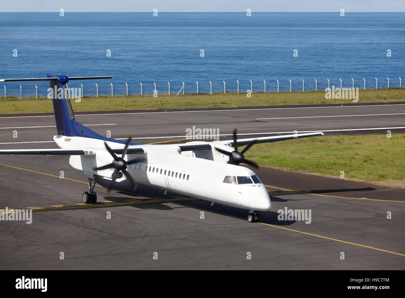 Airplane on the airport runaway near the ocean just arrived. Horizontal ...