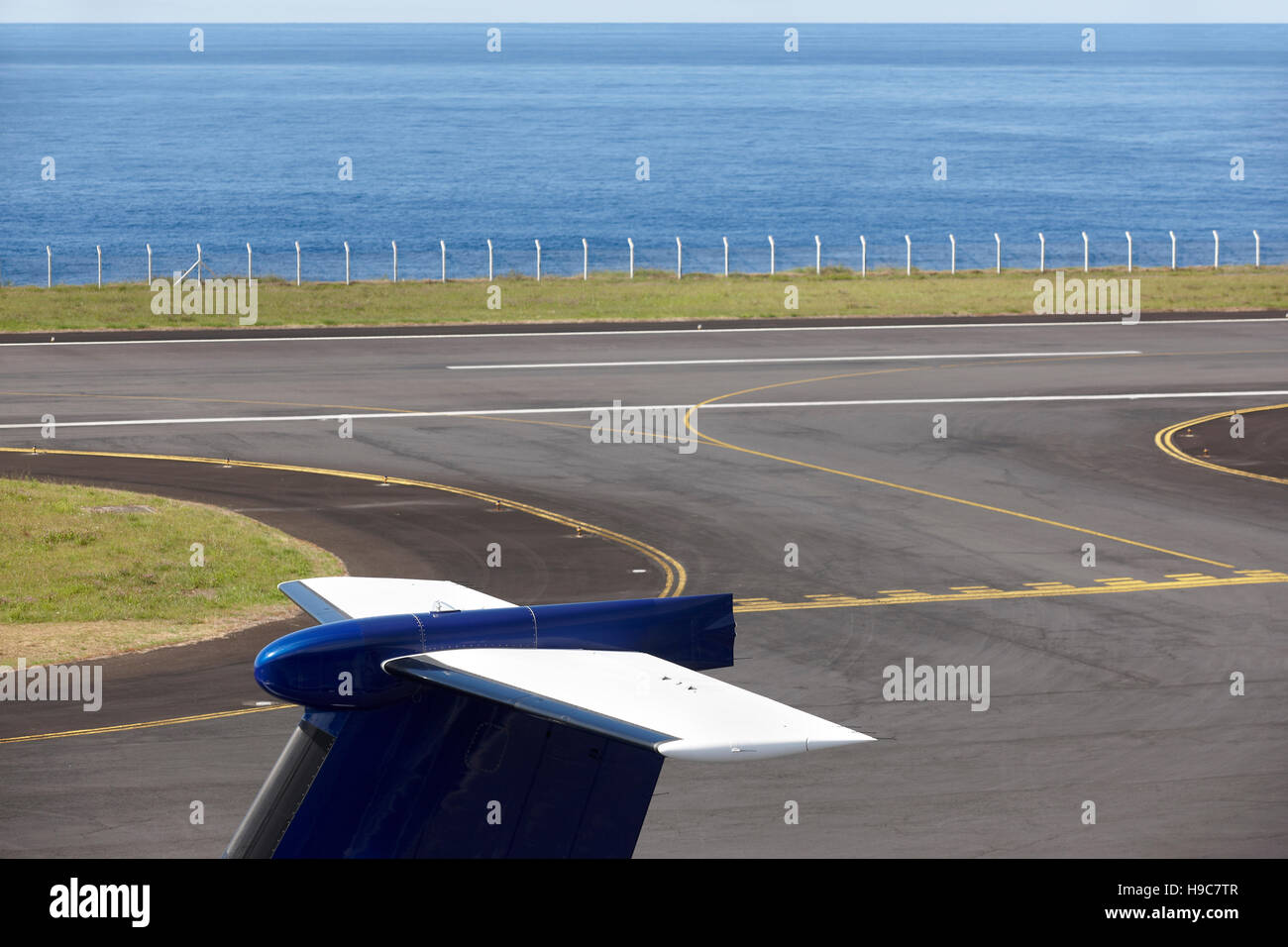 Airport runway near the ocean with airplane tale wing detail ...