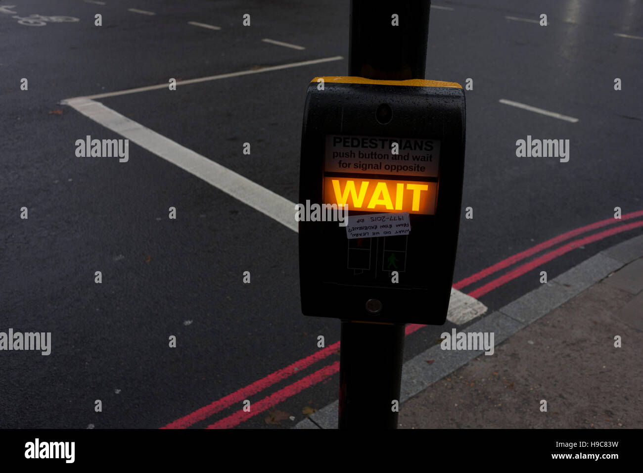 A 'Wait' warning to pedestrians, illuminated on a road crossing sign in ...