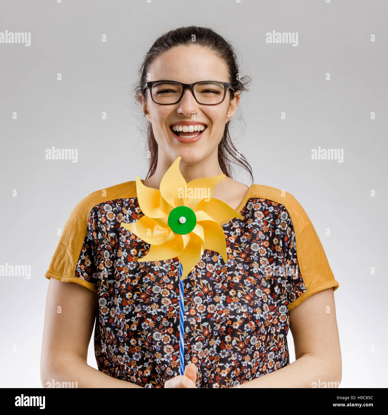 Portrait of a happy woman playing with a windmill Stock Photo - Alamy