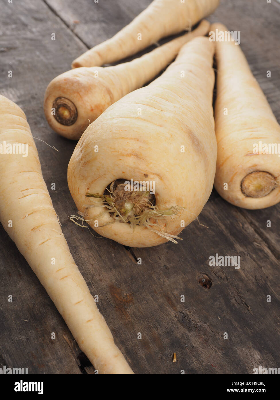 Raw parsnip on an old rustic wooden kitchen table Stock Photo - Alamy