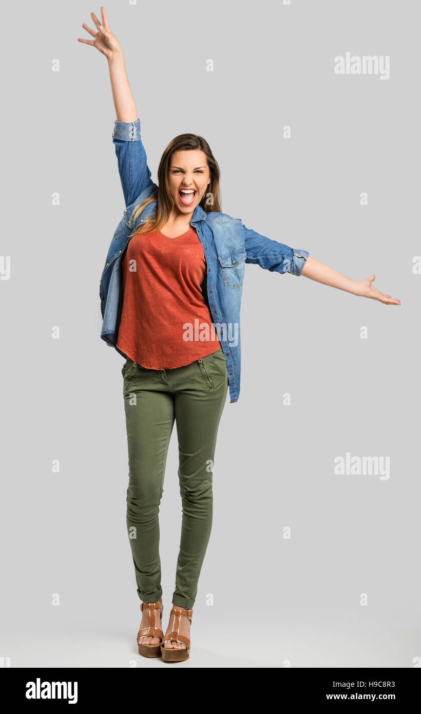 Beautiful happy woman with arms up over a gray background Stock Photo ...