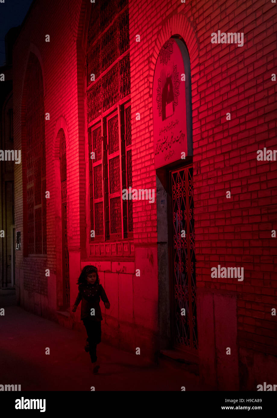 Iranian girl running in a street illuminated with red light for ...