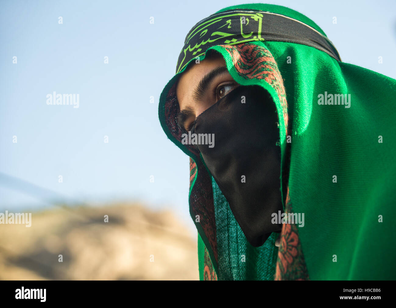Iranian shiite muslim man with his face hidden by a veil mourning imam ...