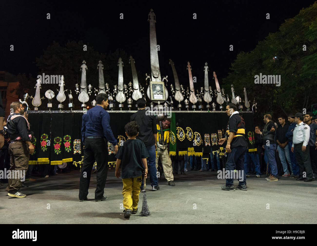 Iranian shiite muslim men carrying an alam during muharram, Lorestan ...
