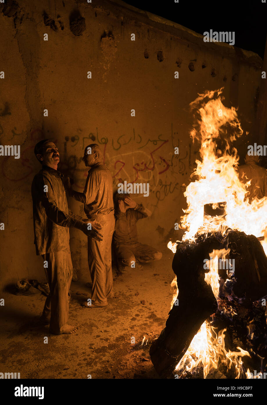 Iranian shiite muslim men gather around a bonfire after rubbing mud on ...