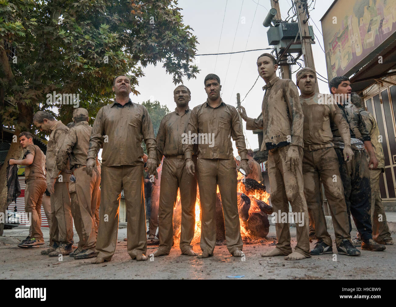 Iranian shiite muslim men gather around a bonfire after rubbing mud on ...