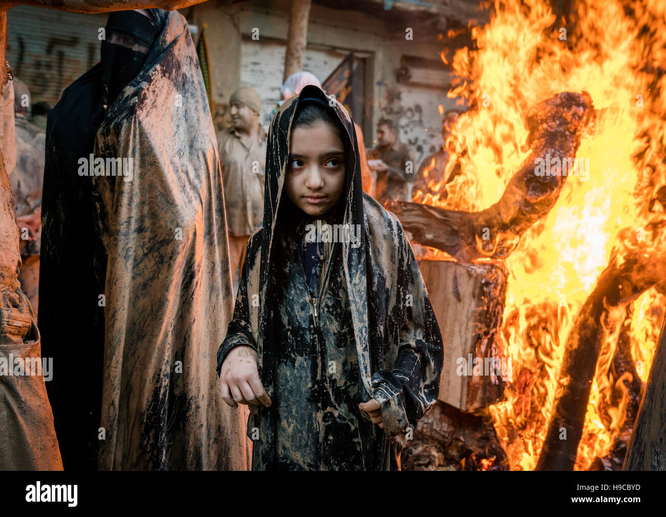 Iranian shiite muslim girls gather around a bonfire after rubbing mud ...