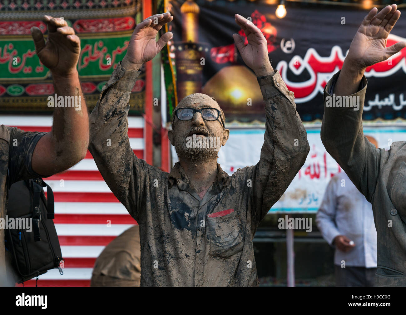 Iranian shiite muslim men praying after rubbing mud on their clothes ...