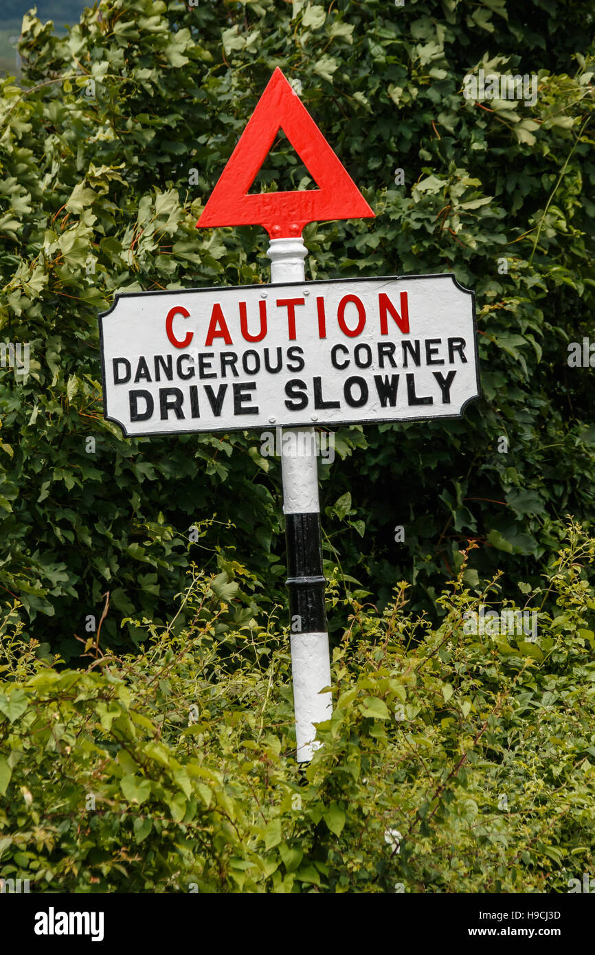 Old fashioned road sign, caution dangerous corner drive slowly Stock ...
