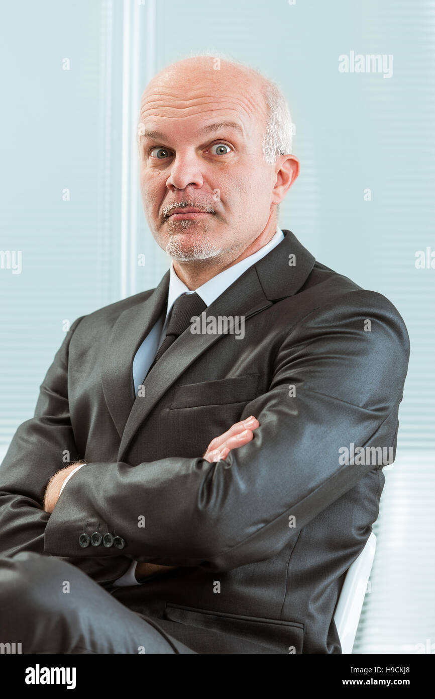 manager or formal office worker with his arms folded and making a very ...