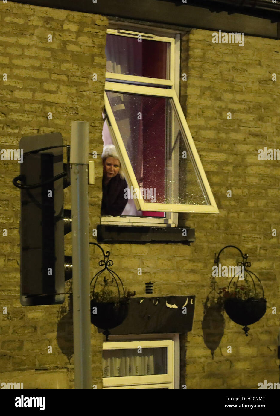 A resident looks out from a first floor window at the flooding on ...