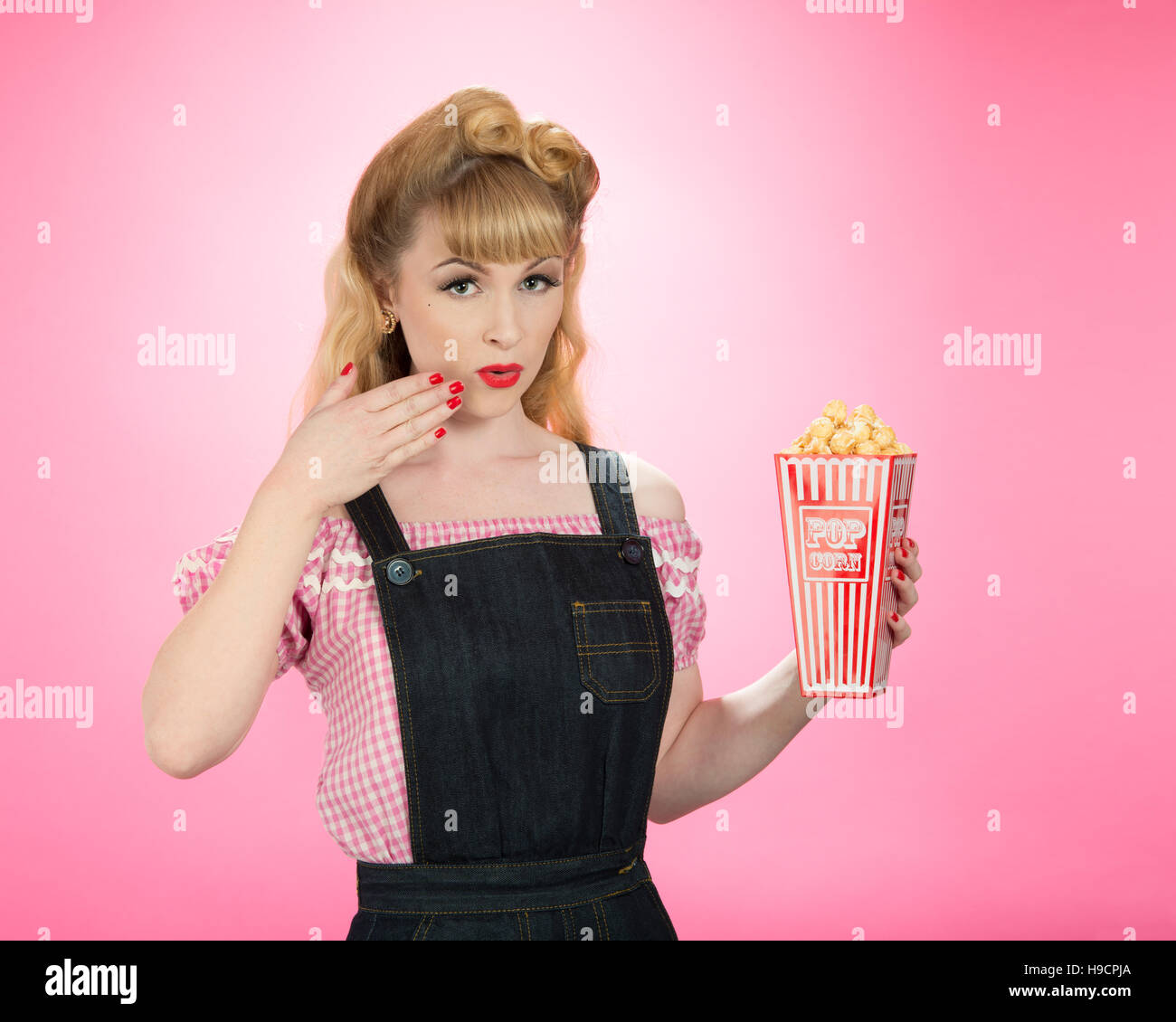 Pin up girl with carton on popcorn on a bright pink background Stock ...