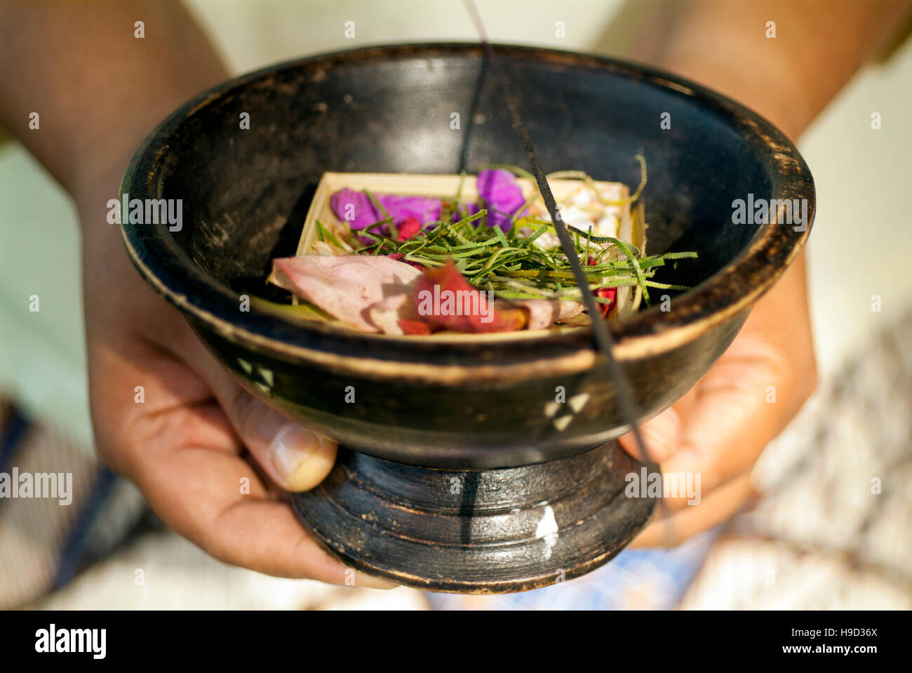 A canang sari religious offering in a bamboo basket filled with flowers ...