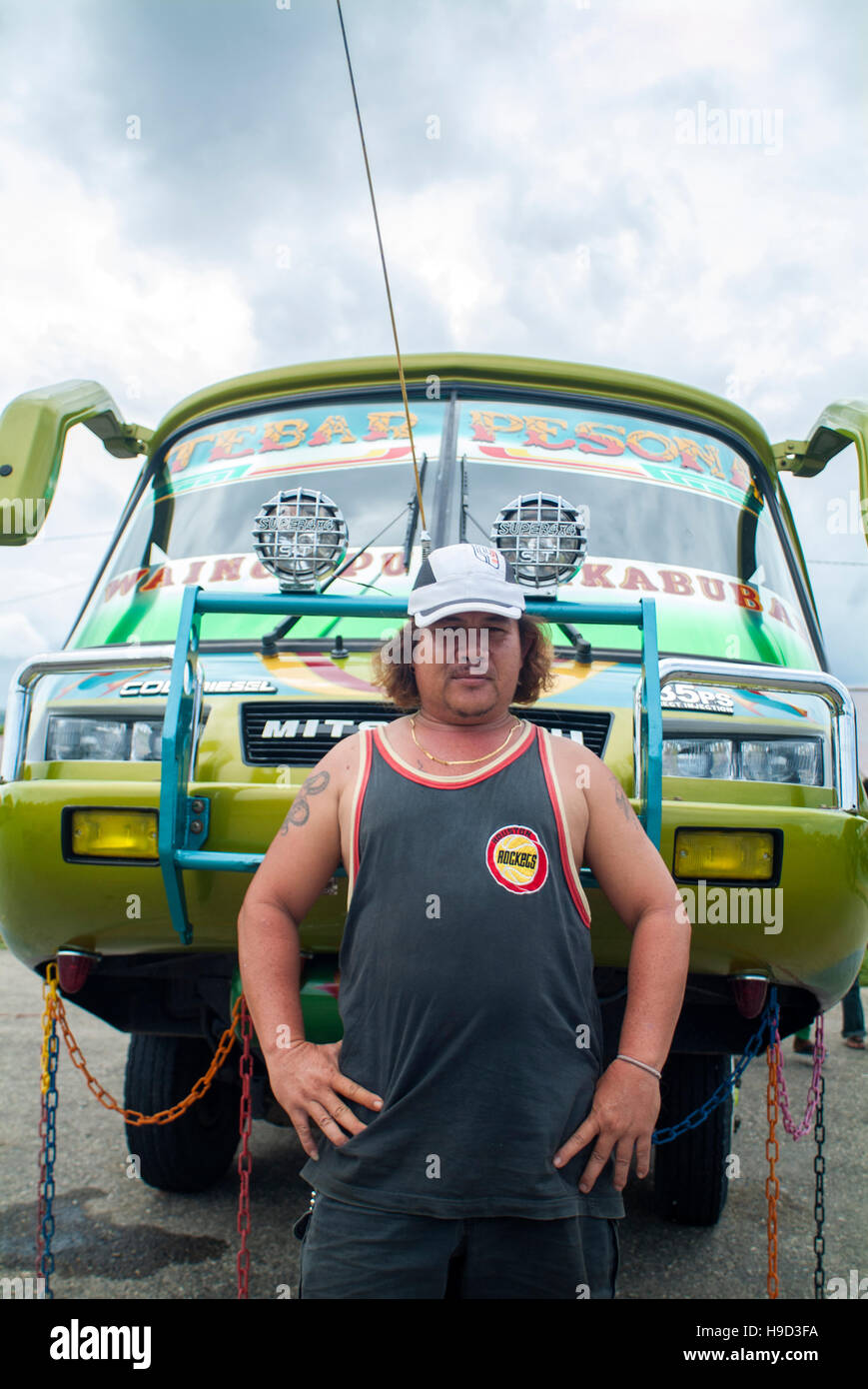 A bus driver in front of his decorated vehicle on the island of Sumba ...